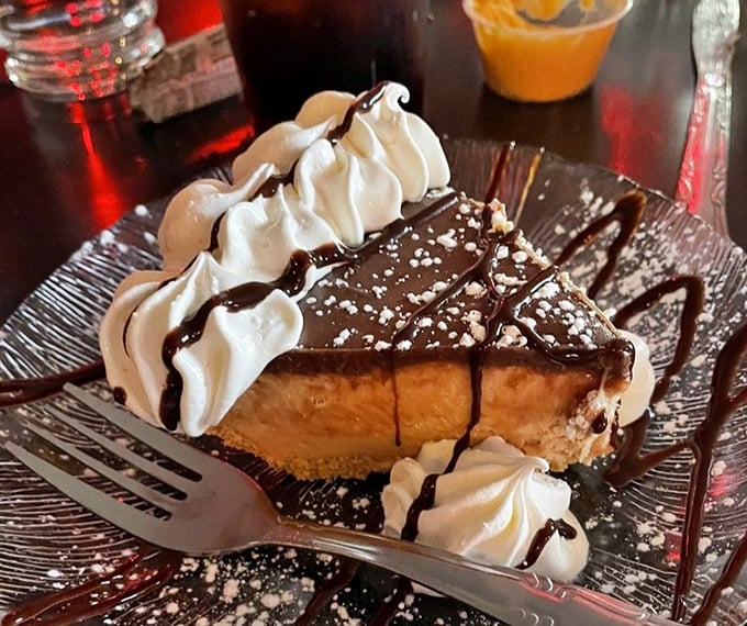 Chocolate peanut butter pie that makes sharing feel like a sacrifice. Those dollops of whipped cream aren't garnish – they're essential supporting characters.