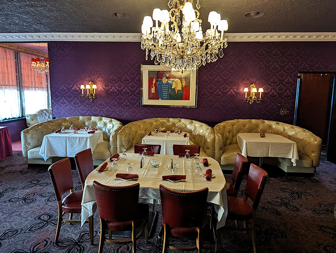 Elegant booth seating under crystal chandeliers creates intimate dining spaces where countless anniversaries and proposals have been celebrated.