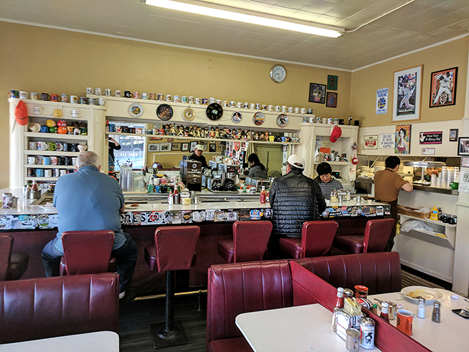 The counter at Eddie's &ndash; where regulars perch on red vinyl stools, watching breakfast magic happen while surrounded by decades of collected mugs and memorabilia.