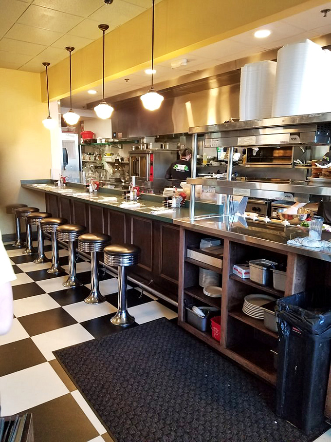 The diner counter&mdash;where solo diners become regulars and the magic happens behind stainless steel. A front-row seat to breakfast theater.