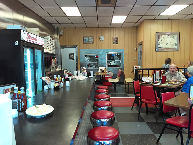 Counter seating where regulars have claimed their spots for years, watching the kitchen ballet while trading stories over bottomless coffee.