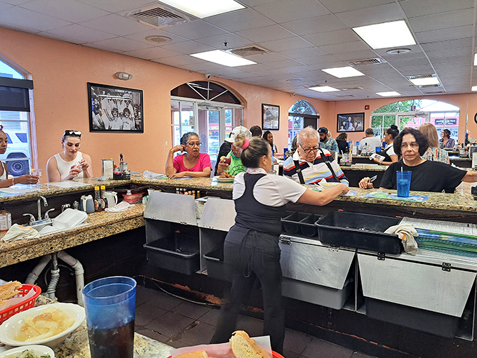 The bustling counter scene where regulars gather like family, sharing stories and strong coffee in true Cuban caf&eacute; tradition.