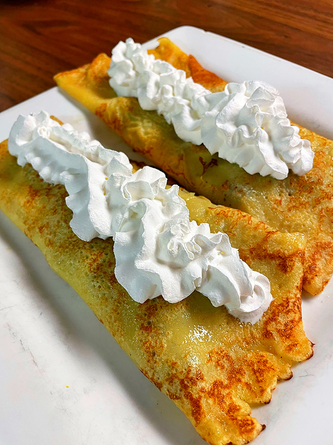 Crepes dressed in their Sunday best with whipped cream clouds – proof that breakfast can be both a meal and a celebration.