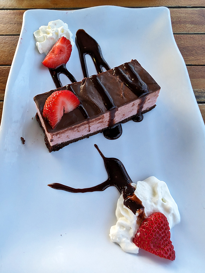 Chocolate layered dessert with fresh strawberries&mdash;because after all that seafood, your sweet tooth deserves its moment in the spotlight too.