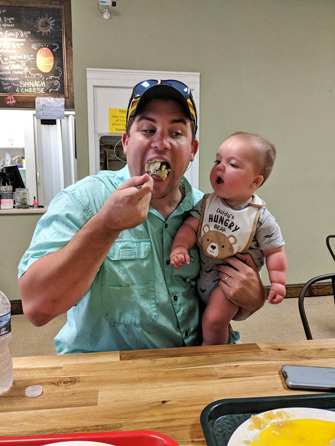 The image shows a customer enjoying a pierogi while holding a baby&mdash;proving that good taste is hereditary and Polish comfort food spans generations.