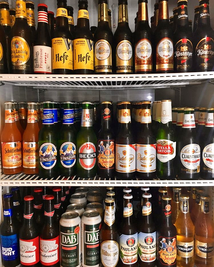 The beer fridge of dreams! German brews line the shelves like liquid ambassadors, each bottle promising authentic Bavarian refreshment.