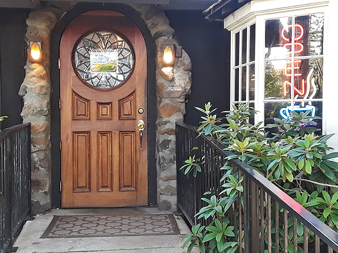 The entrance says "storybook cottage" but the neon sign whispers "come hungry." That round window has witnessed countless food-induced smiles over the years.