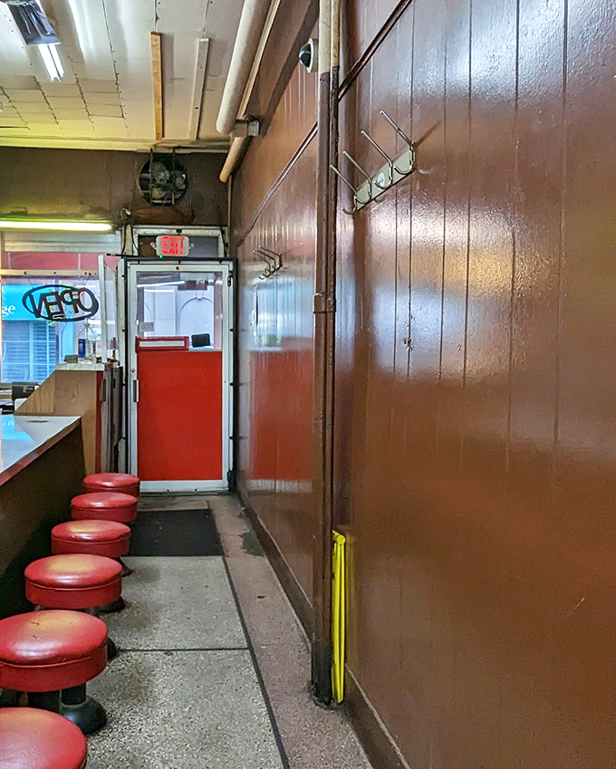 The exit corridor lined with those classic red stools&mdash;each one having supported countless satisfied customers over decades of Detroit dining history.