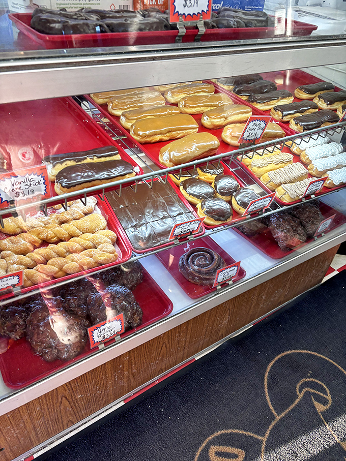 The display case&mdash;a museum of fried artistry where each shelf offers a different exhibition of donut craftsmanship.