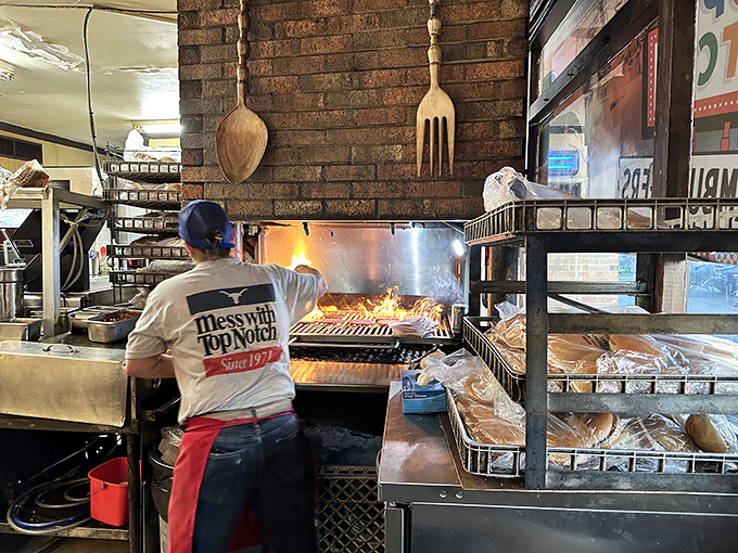 Where the magic happens—flames dancing beneath burgers while decades of cooking wisdom gets passed down like family heirlooms.