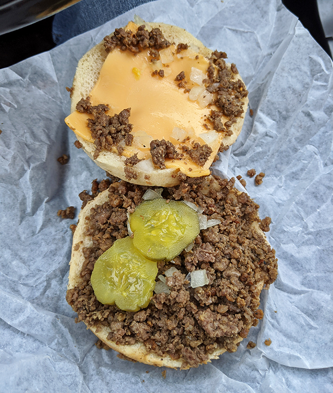 Behold the architectural marvel – loose meat, pickles, and cheese creating a perfect ratio that engineers would envy.