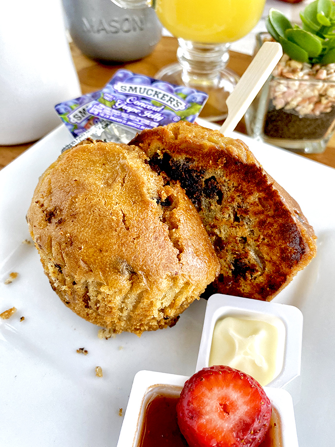 A muffin that looks like it could win a bake-off, served with butter and jam because some traditions should never change.