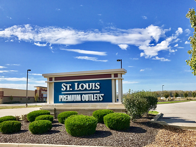 The gateway to retail therapy stands proudly under Missouri skies. Those manicured shrubs have witnessed countless shoppers arriving with empty trunks and leaving with full hearts.