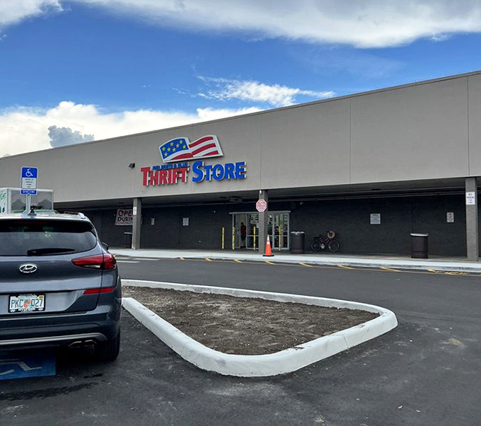 The exterior view that beckons bargain hunters like a patriotic retail lighthouse. Where shopping meets treasure hunting under the Florida sun.