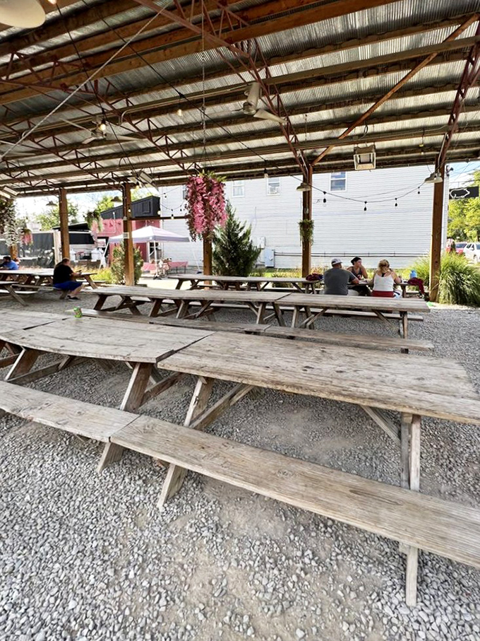The covered outdoor seating area transforms into a community gathering spot where strangers become friends over shared barbecue enthusiasm.