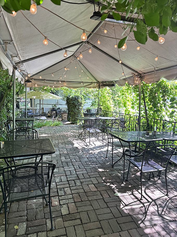 Dappled sunlight filters through the canopy of this outdoor dining oasis&mdash;string lights standing by for when evening falls.