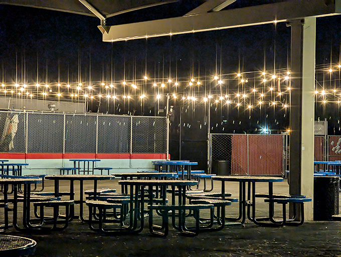 String lights transform this outdoor seating area into a magical gathering space where strangers become temporary neighbors in the glow of movie magic.