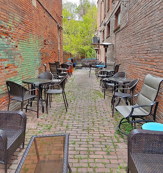 Brick walls create a secret garden atmosphere in this alleyway dining space, where tables await those seeking fresh air with their fresh cuisine.