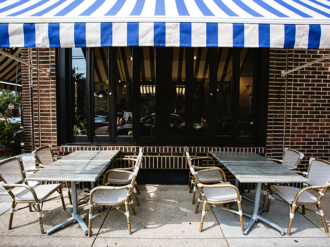 The outdoor seating area waits patiently under blue and white stripes &ndash; like a Parisian caf&eacute; that somehow wandered into Philadelphia and decided to stay.