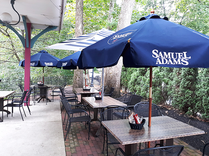 The outdoor patio, shaded by blue umbrellas and surrounded by greenery, offers the perfect setting for that "I'm not going back to work" extended lunch.