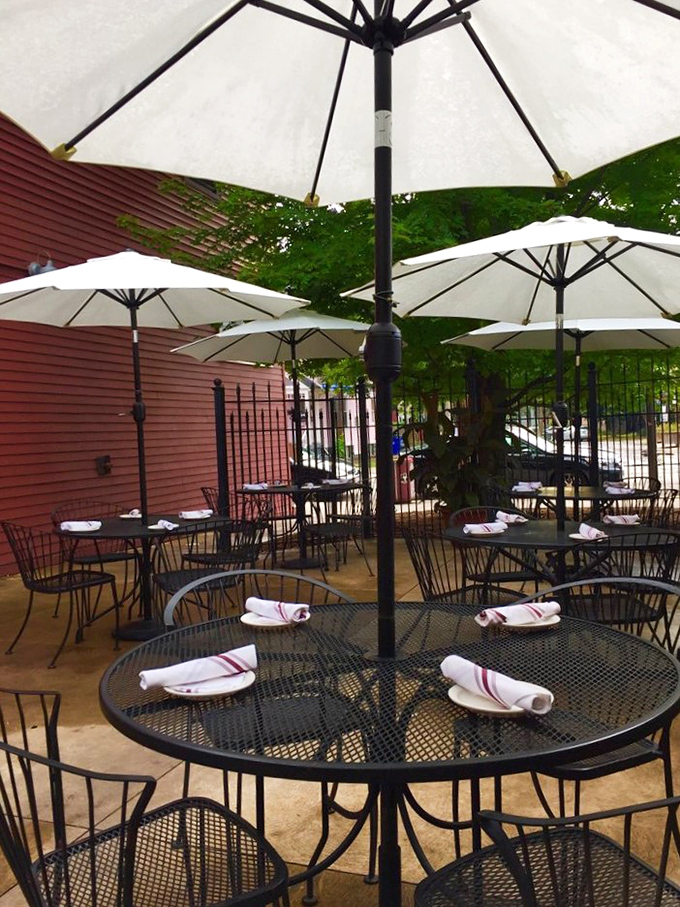 The outdoor patio offers a serene escape from Cleveland's urban bustle, with white umbrellas standing guard over tables ready for summer feasting.