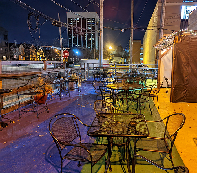 As night falls, the patio transforms into a twinkling urban retreat where city lights compete with string lights for atmospheric dominance.