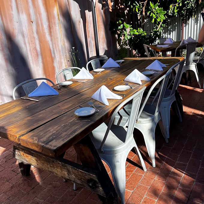 Al fresco dining where rustic wooden tables and modern metal chairs create the perfect backdrop for memorable meals under California skies.