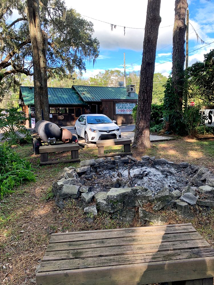 Where smoke meets sky &ndash; the fire pit and outdoor seating area promise an authentic barbecue experience under Spanish moss-draped trees.