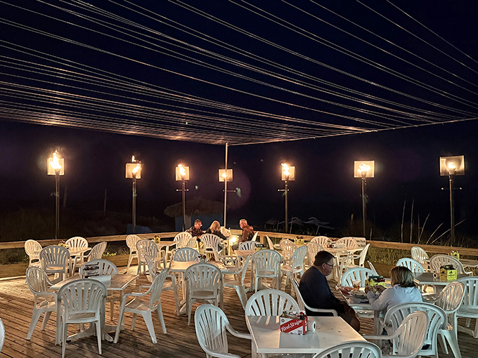 As night falls, the torch-lit deck transforms into a magical dining experience where the sound of waves provides the perfect dinner soundtrack.