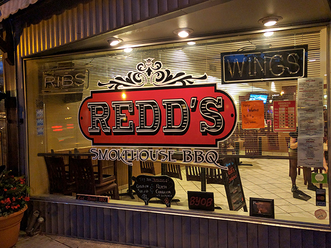 Evening transforms the storefront into a glowing invitation to indulge in smoky delights that have made Redd's a Pennsylvania BBQ destination.