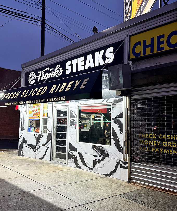 As night falls, Frank's glows like a culinary lighthouse guiding hungry souls through the darkness toward cheesesteak salvation.