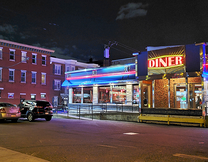 At night, the diner transforms into a glowing blue-and-neon oasis, beckoning night owls and early risers with the promise of pancakes at any hour.