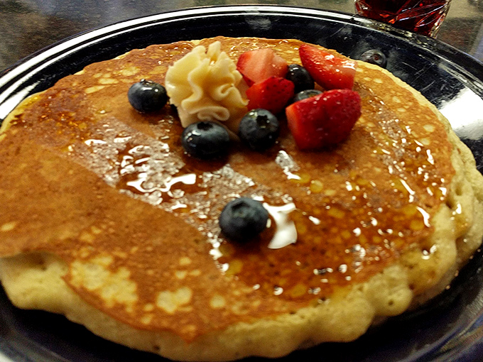 A pancake that understands the importance of accessorizing. Those fresh berries aren't just garnish &ndash; they're jewelry for your breakfast.
