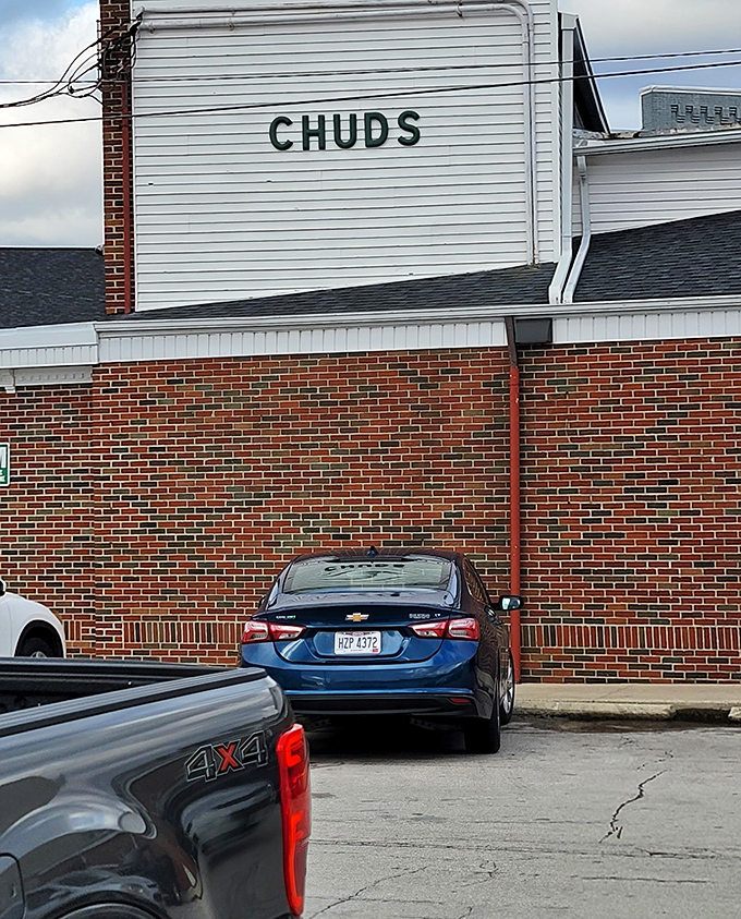 The unassuming parking area outside Chud's&mdash;where hungry arrivals and satisfied departures create a constant cycle of culinary happiness.