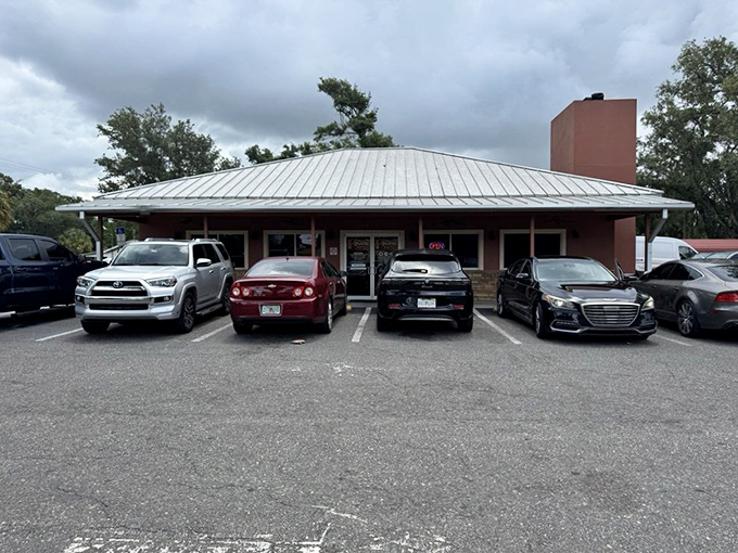 A parking lot democracy where luxury sedans and work trucks unite in their quest for authentic Alabama barbecue.