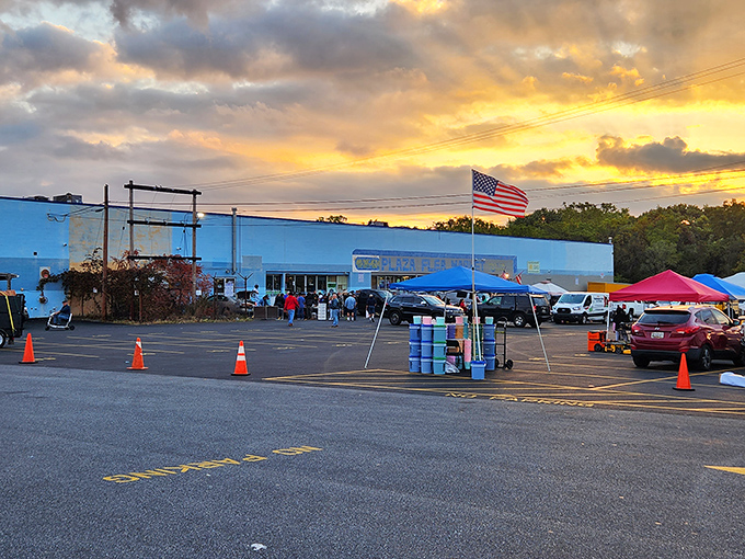 As the sun sets on another day of deal-hunting, the blue building and American flag create the perfect backdrop for flea market magic.