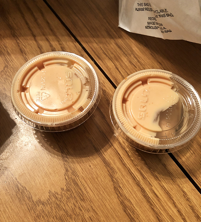 Two containers of sauce wait patiently, ready to elevate your meal from good to absolutely unforgettable with every dip.