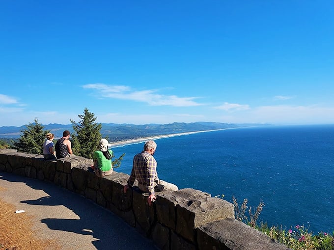 Humans for scale: Even the tallest visitor becomes humbled before the vast expanse of Oregon's coastline stretching into forever.
