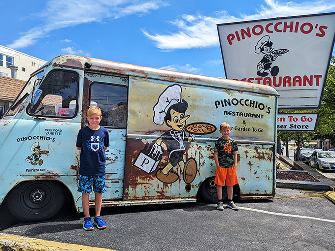 Two young pizza enthusiasts posing with the legendary truck&mdash;creating memories that will last longer than leftovers in the fridge. 