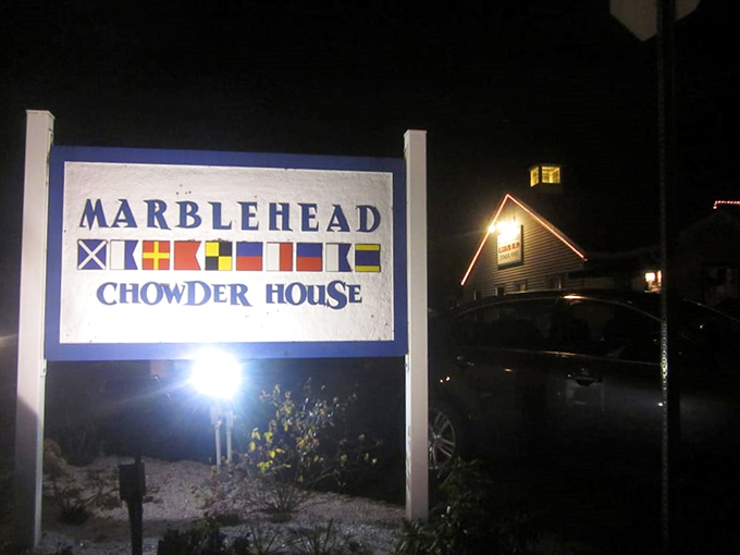 Even at night, the illuminated Marblehead sign with nautical flags serves as a beacon for those craving coastal cuisine.
