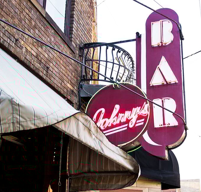 Johnny's vintage BAR sign glows like a purple promise of exceptional meals and memories waiting just inside those doors.