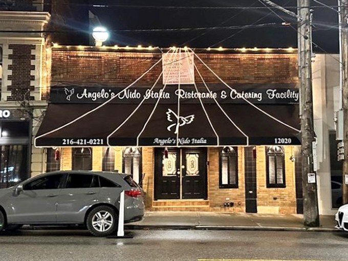 As night falls, the illuminated fa&ccedil;ade of Angelo's Nido Italia serves as a beacon for hungry travelers seeking authentic Italian comfort.