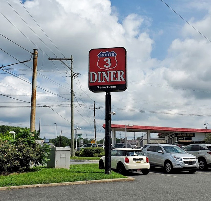 The Route 3 Diner sign stands tall against Delaware skies, promising 7am-10pm of comfort food possibilities for the hungry and hopeful.