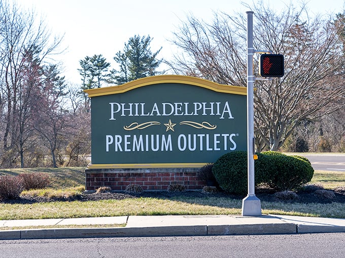The entrance sign stands sentinel, promising premium experiences without premium prices. That elegant curve at the top is the retail equivalent of a welcome smile. 