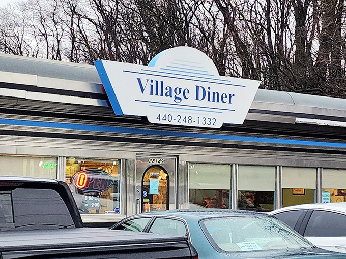 The Village Diner sign stands as a beacon of hope for the hungry, promising that inside those doors, breakfast nirvana awaits. 
