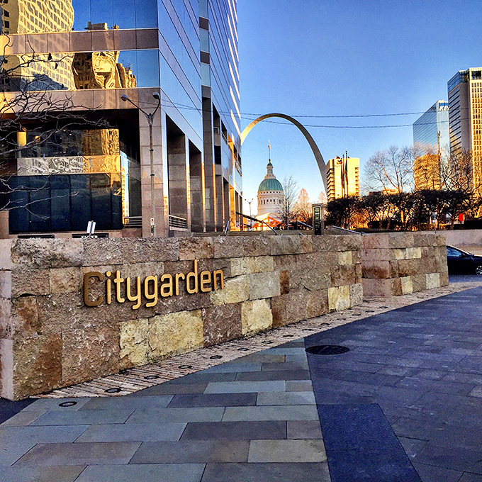With the iconic Gateway Arch visible in the distance, Citygarden's entrance sign anchors this artistic oasis in the heart of St. Louis.