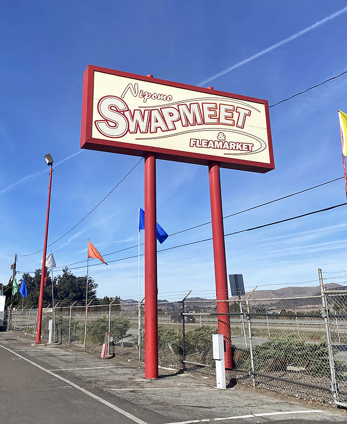 The iconic Nipomo Swap Meet sign stands tall against blue skies, a beacon for bargain hunters and treasure seekers alike.