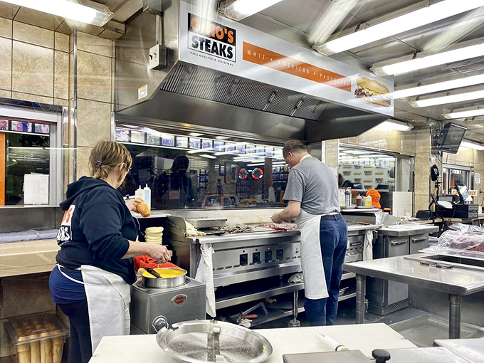 The grill masters at work, turning simple ingredients into legendary meals. Their practiced hands move with the precision of culinary conductors.