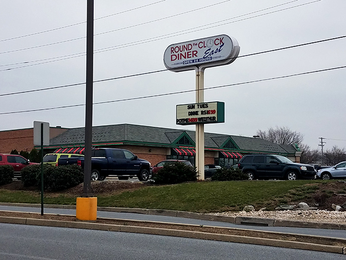 The roadside sign stands tall, a 24-hour promise that whenever hunger strikes, Round the Clock Diner - East has your back.