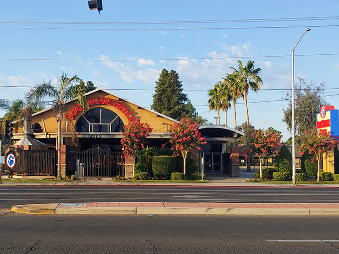 Morning light showcases Dog House Grill's distinctive yellow exterior and red signage, standing proud against a quintessential California blue sky.